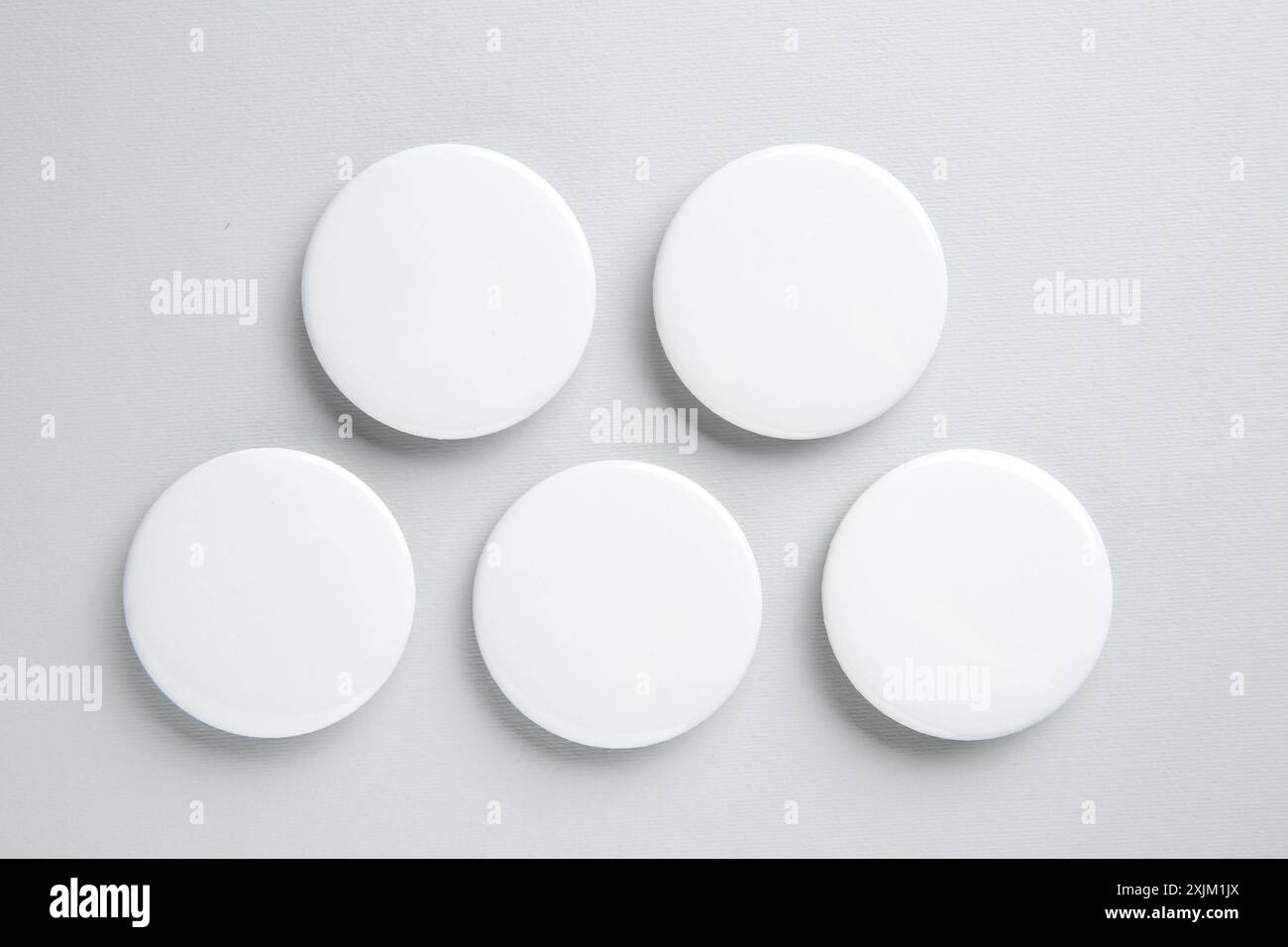 Blank white button badges on light background, flat lay. Mockup for ...