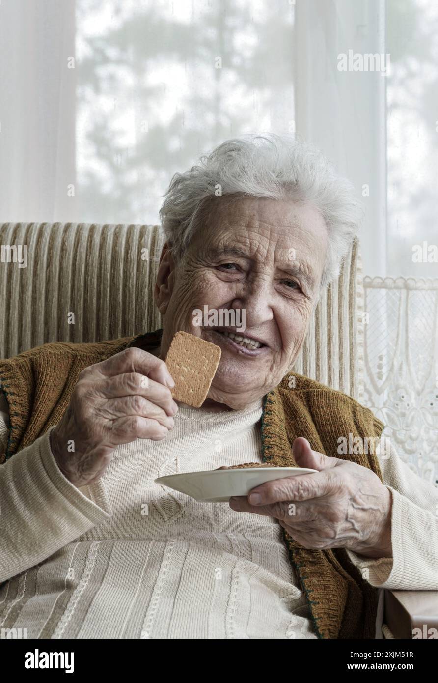 Senior woman eating biscuits hi-res stock photography and images - Alamy