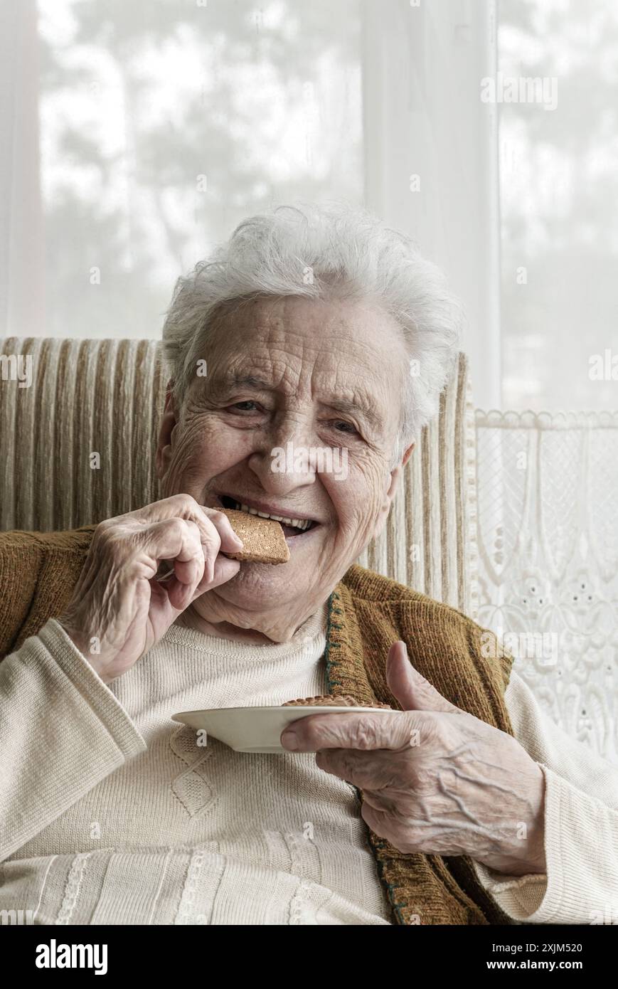 Senior woman eating biscuits hi-res stock photography and images - Alamy