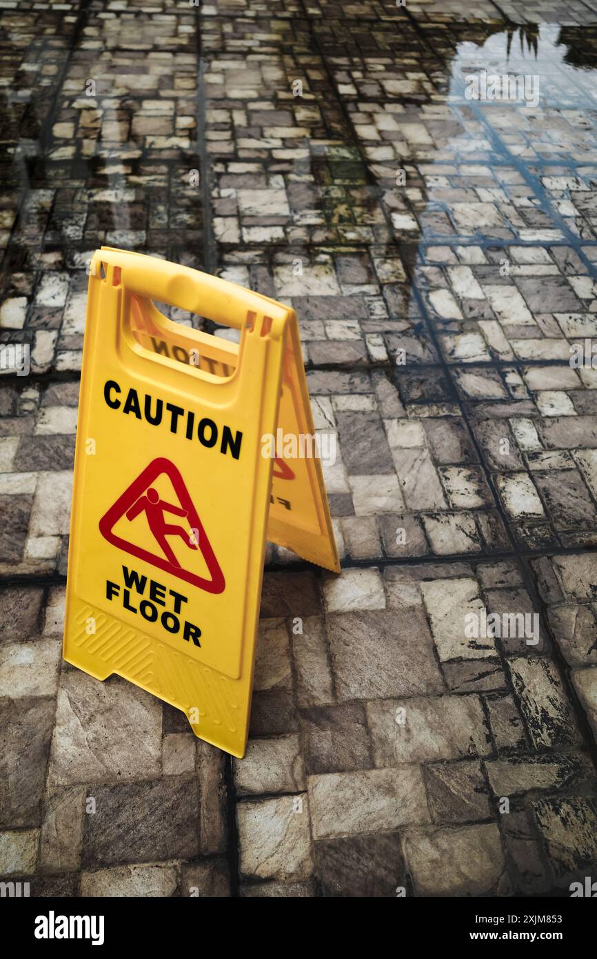 Two yellow plastic warning sign caution wet floor hi-res stock ...