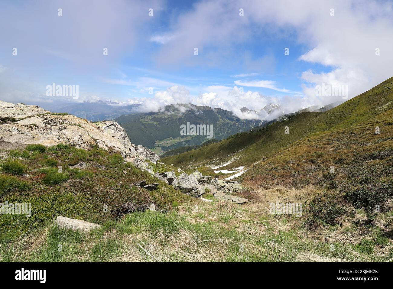 View over a depression in the mountains to a cloudy hazy sky with white ...