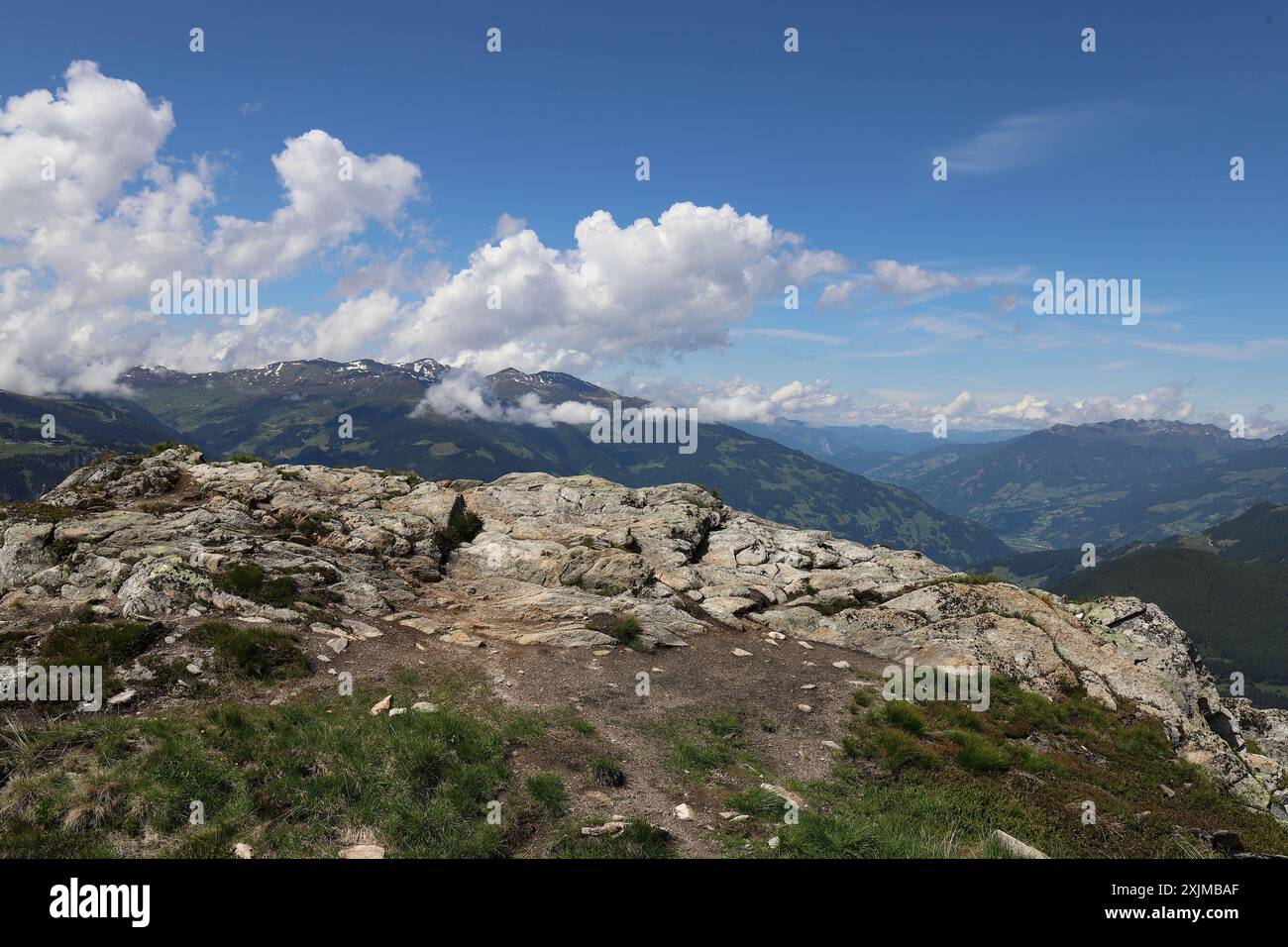 View of barren rock with mountain ranges in the background, cloudy blue ...