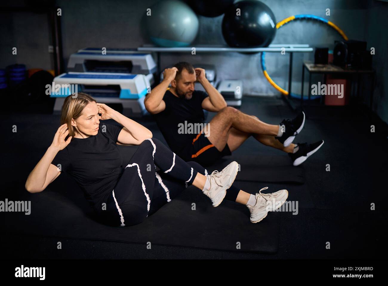Two middle-aged athletes exercising together in fitness. Attractive ...