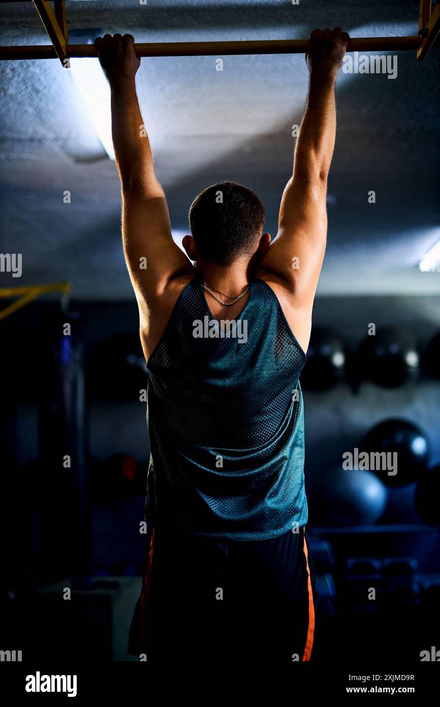 Back view of a strong man doing pull ups in a gym. Fitness and ...