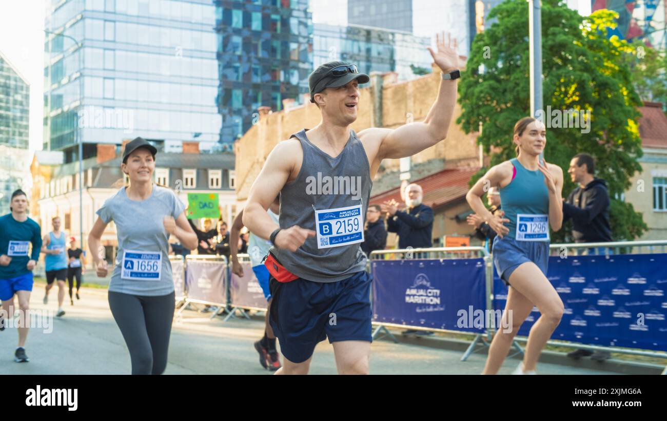 Portrait of Smiling Middle Aged Man Running in a City Marathon, Waving ...
