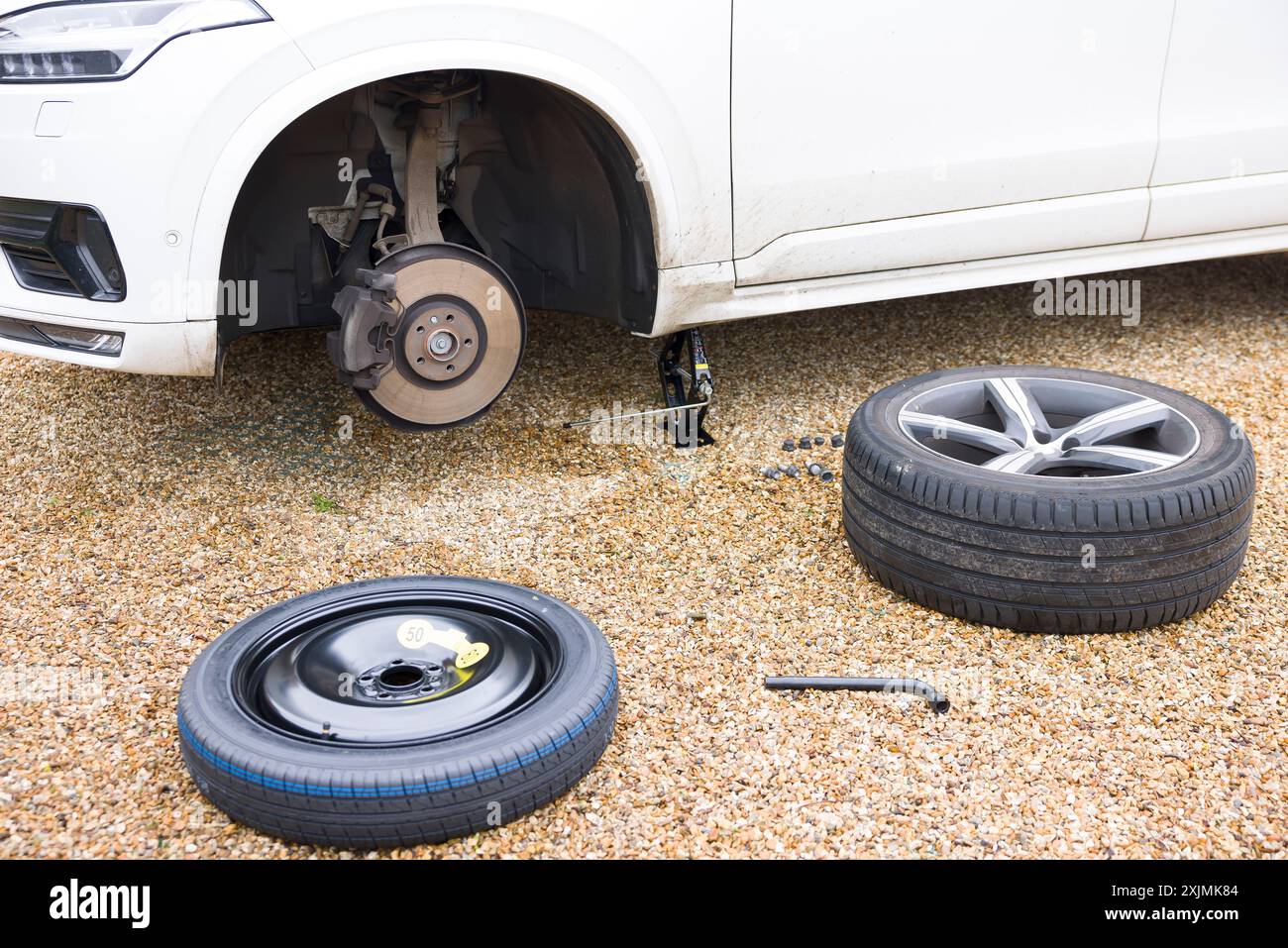 Changing a tyre (tire) on a car, changing a wheel with car on a jack ...