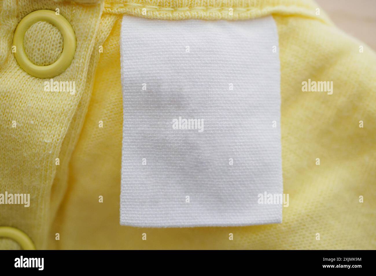 blank white clothing label on yellow fabric texture background Stock ...