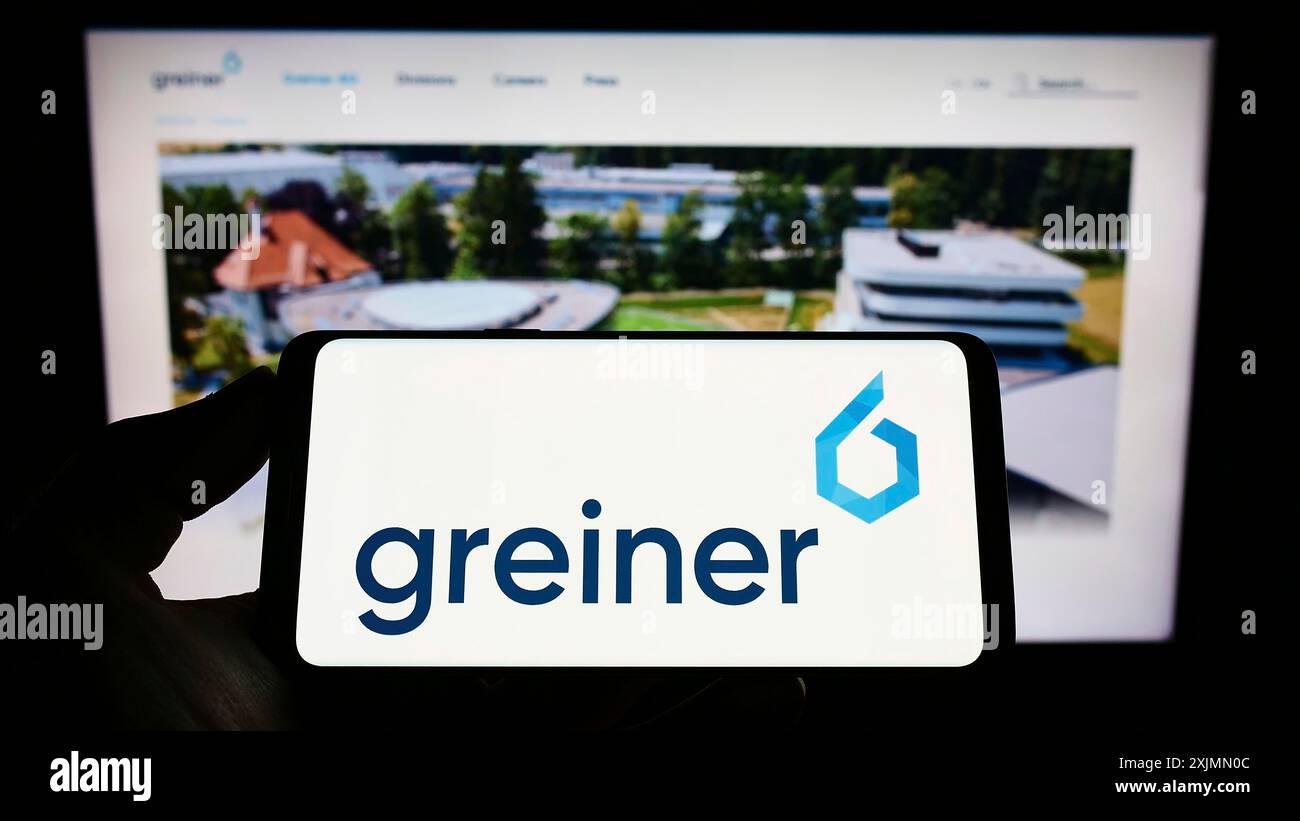 cellphone with logo of Austrian plastics company Greiner AG on screen ...