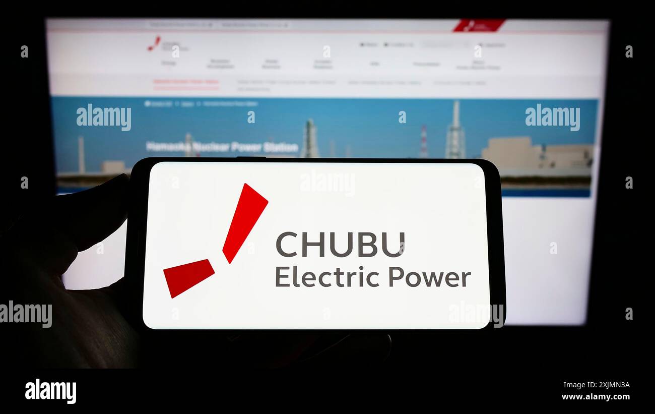 mobile phone with logo of Japanese company Chubu Electric Power Co. Inc. on screen in front of ...