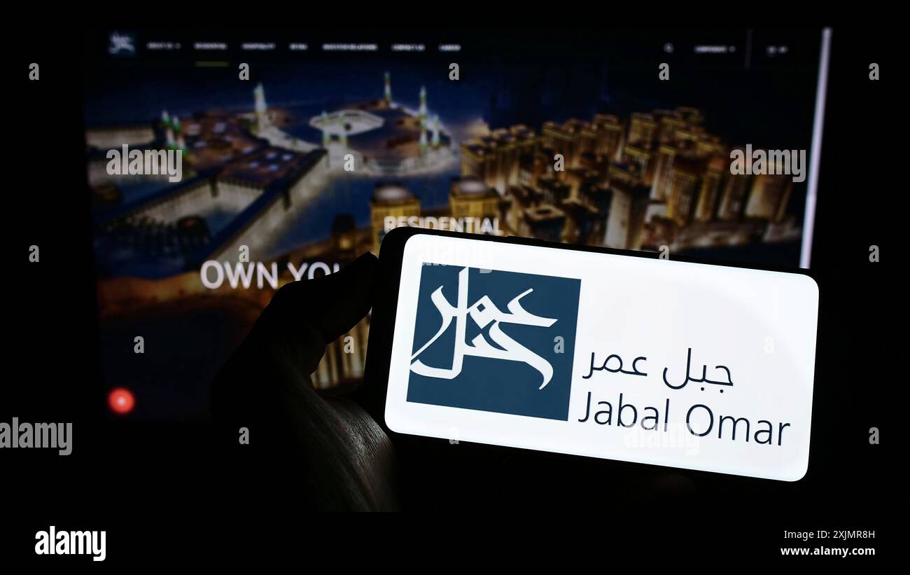 Stuttgart, Germany, 10-02-2022: Person holding cellphone with logo of Jabal Omar Development ...