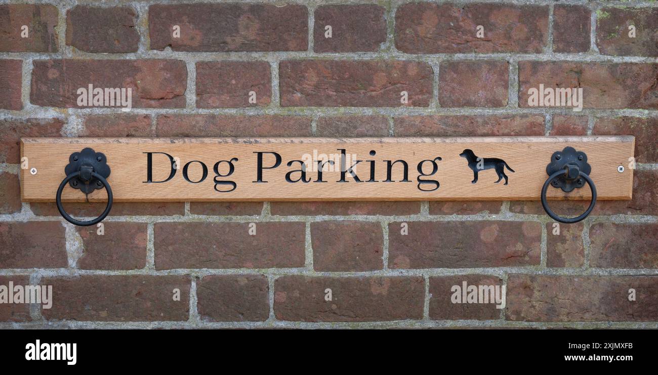 Dog parking sign on brick wall with rings for tying up dogs Stock Photo ...