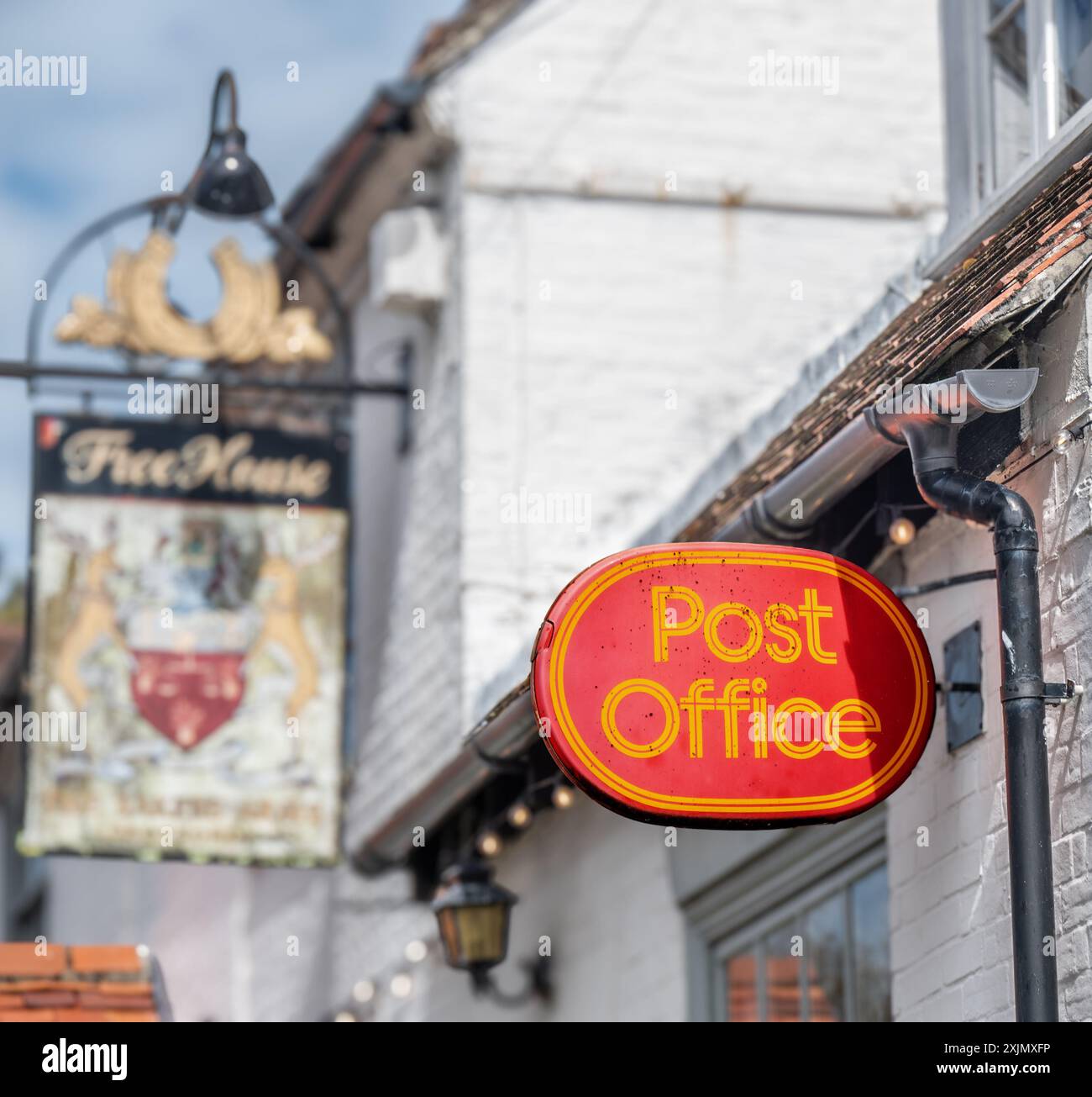 Close up of post office sign and pub sign indicating both businesses ...
