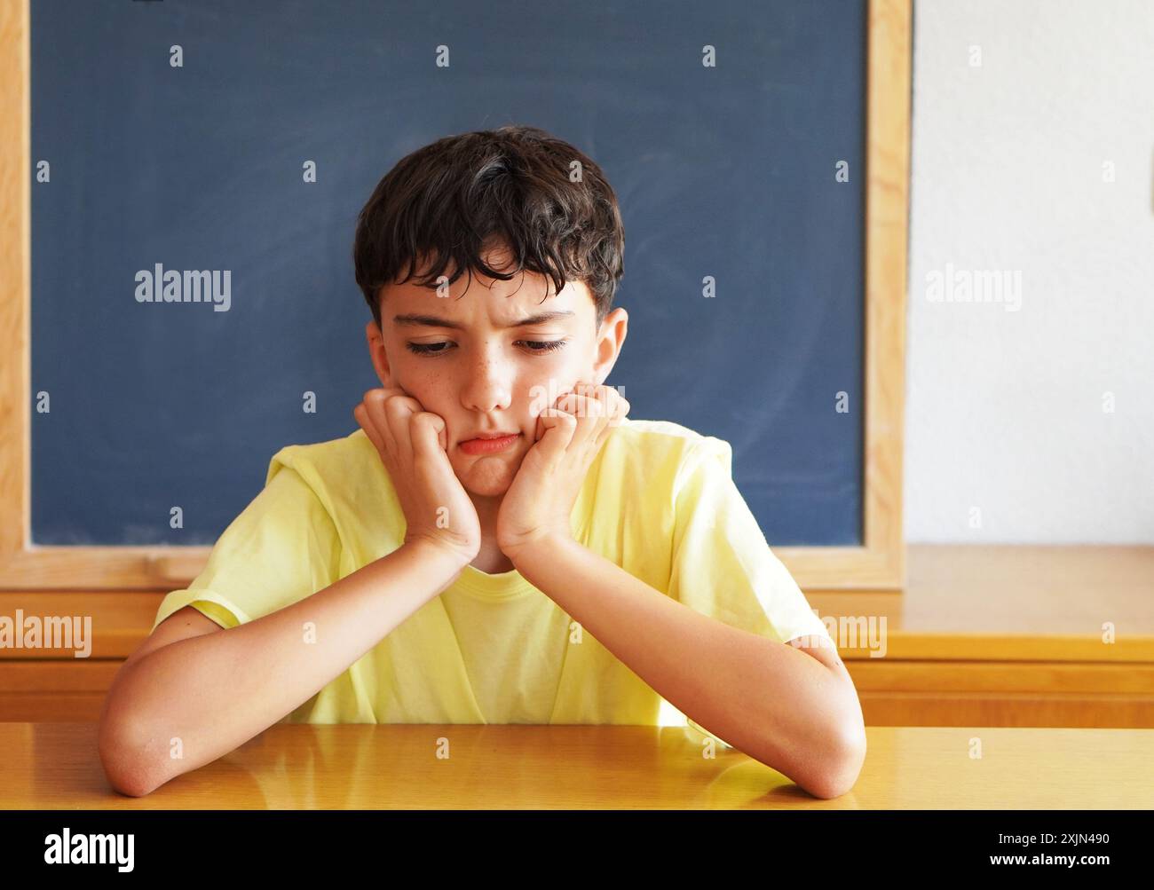 preadolescent child back to school, looking bored and unhappy as he faces the new school year ...
