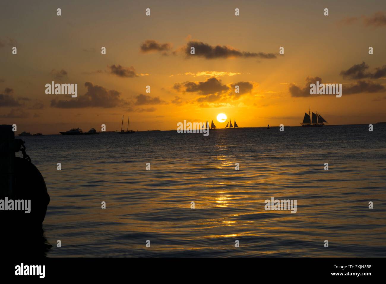 Sun setting between two sailboats with six sails Mallory Square Key ...
