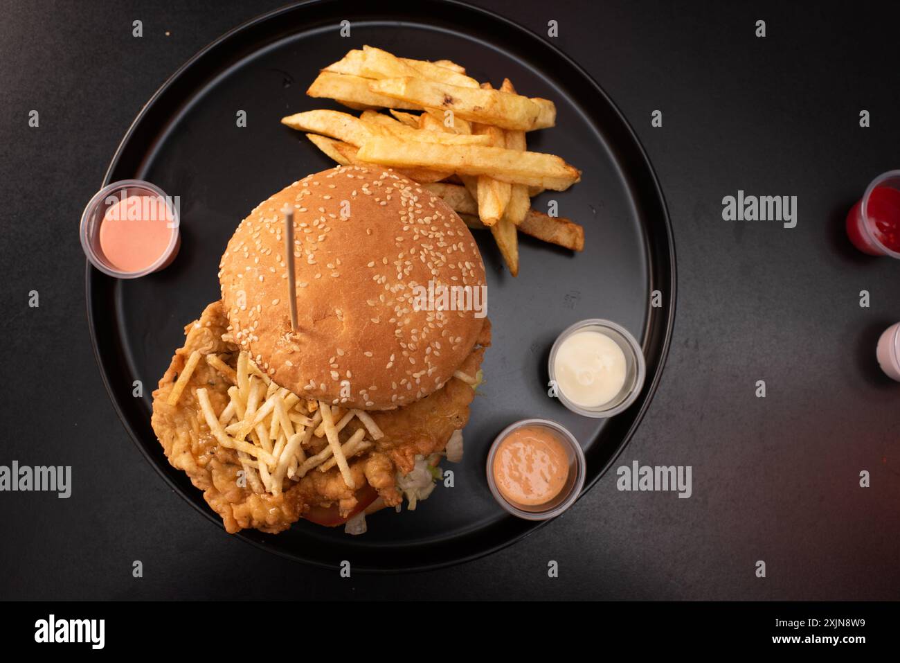 Crispy chicken burger on black background. Tomato, lettuce, chicken ...