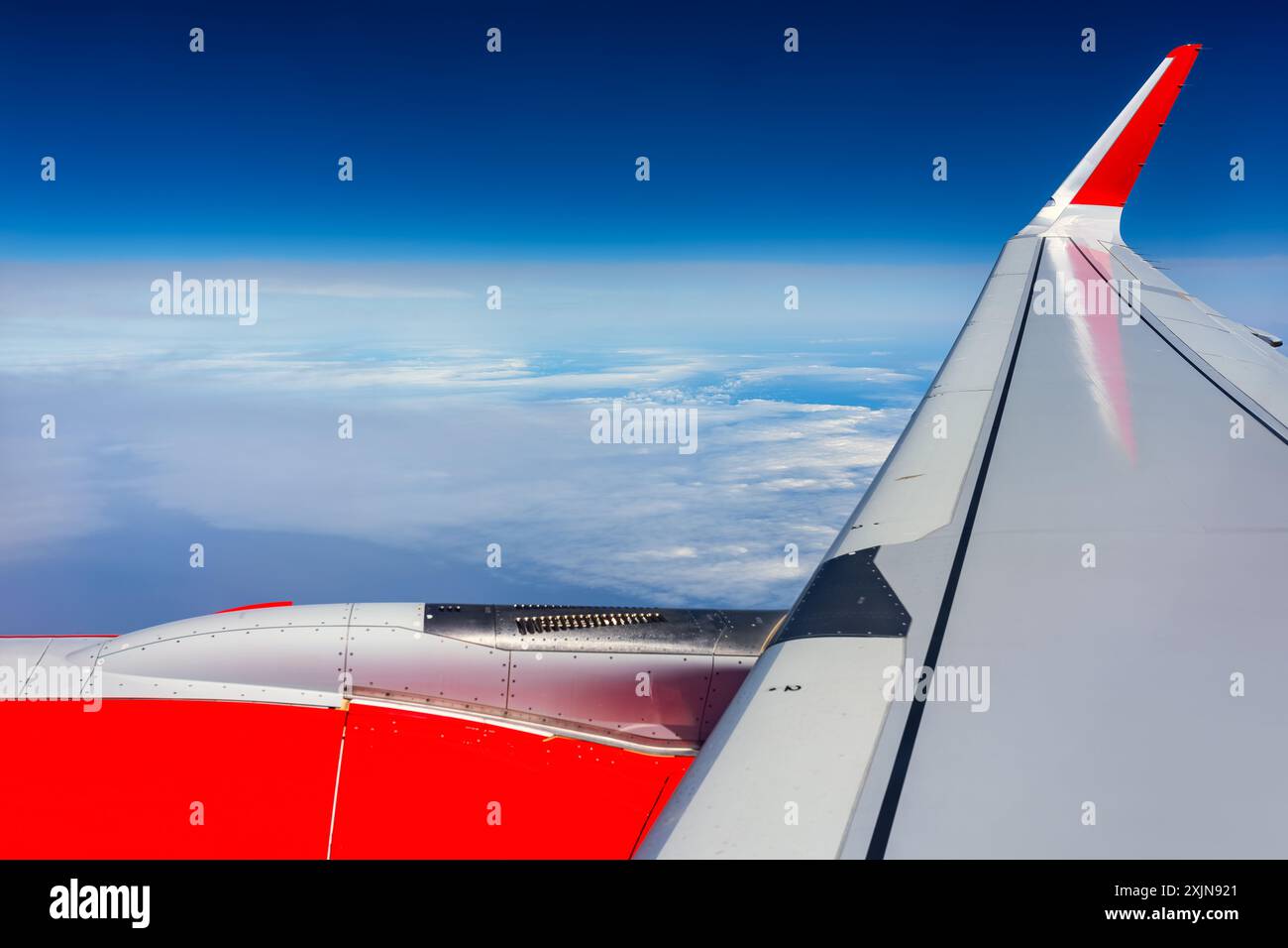 Panoramic view of the wing and engine of an airplane as a sea of clouds ...
