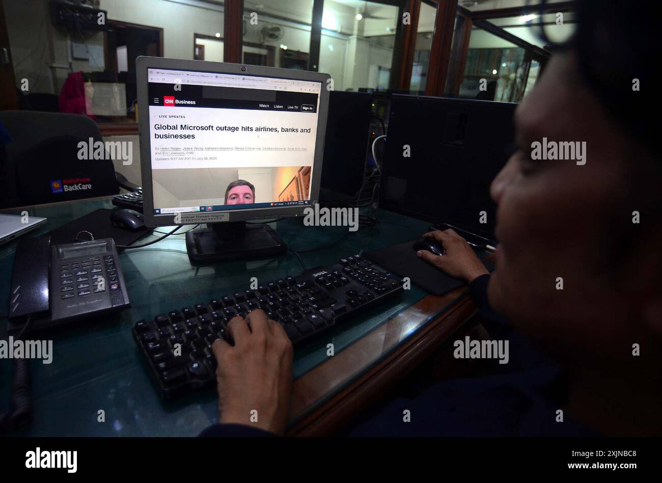 A man reads news of Microsoft global outage on a computer screen in ...