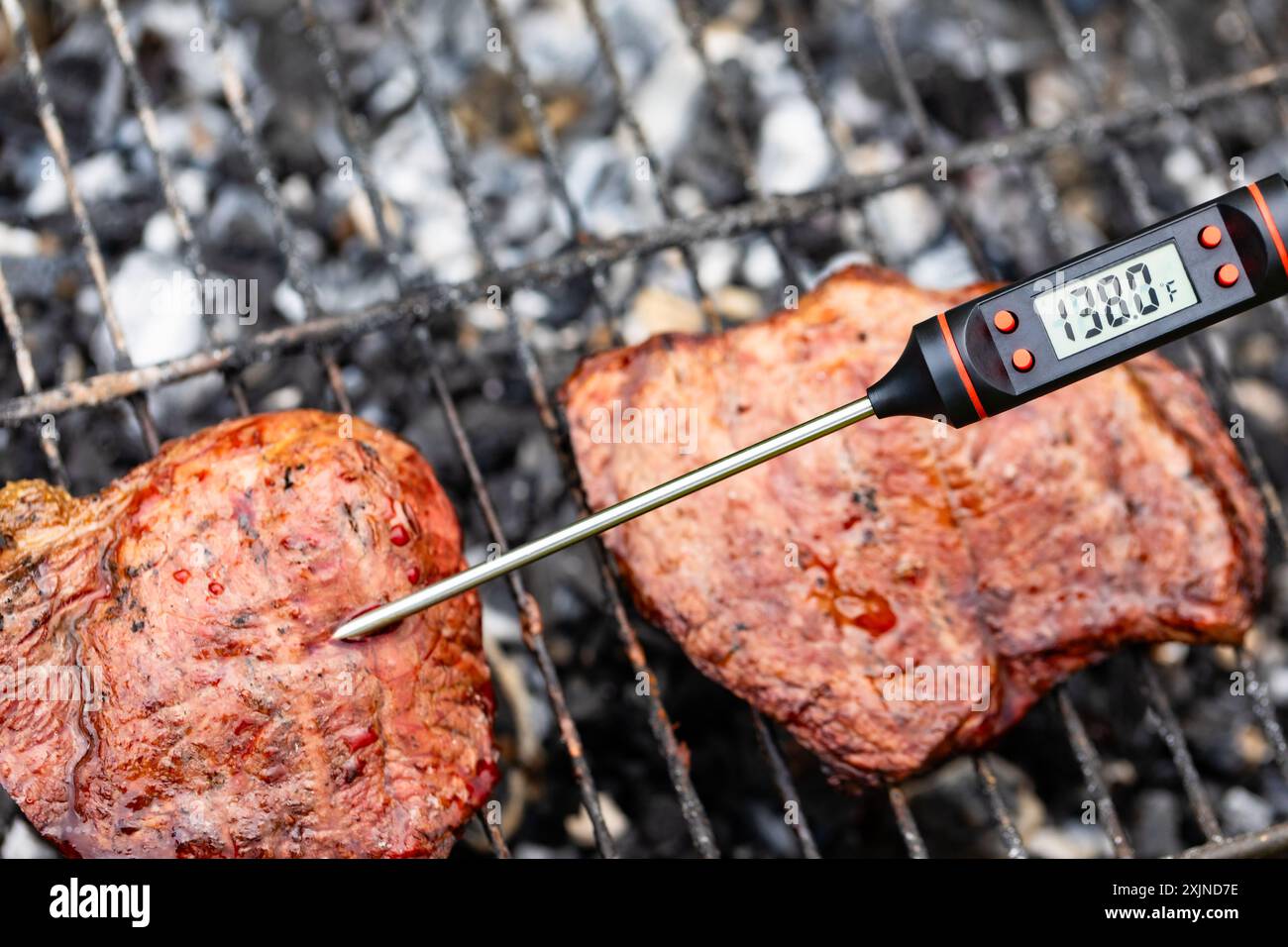 Close-up shot of digital meat thermometer inside grilled steak on ...