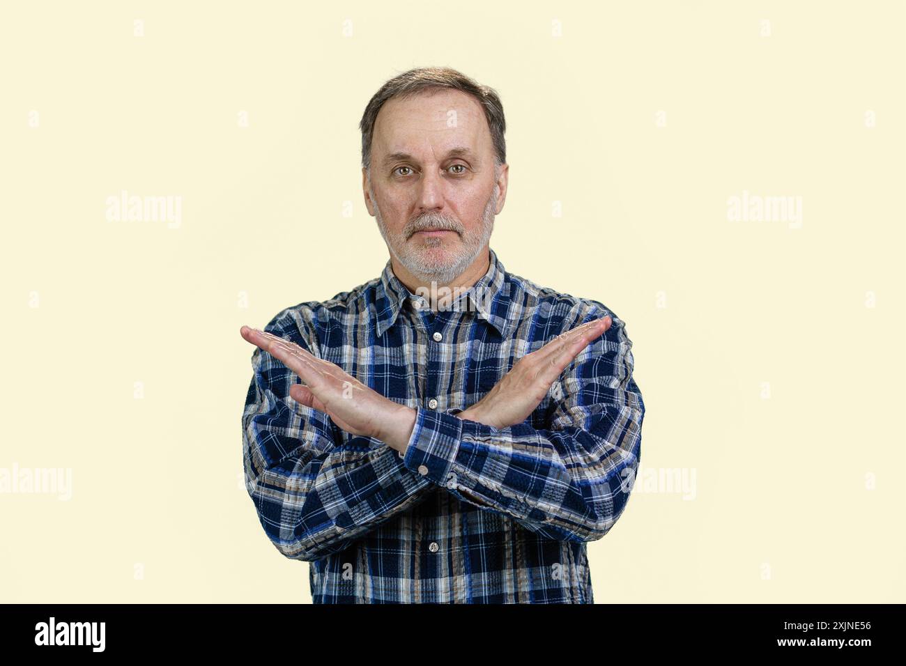 Portrait of a handsome serious man shows reject gesture with arms cross ...