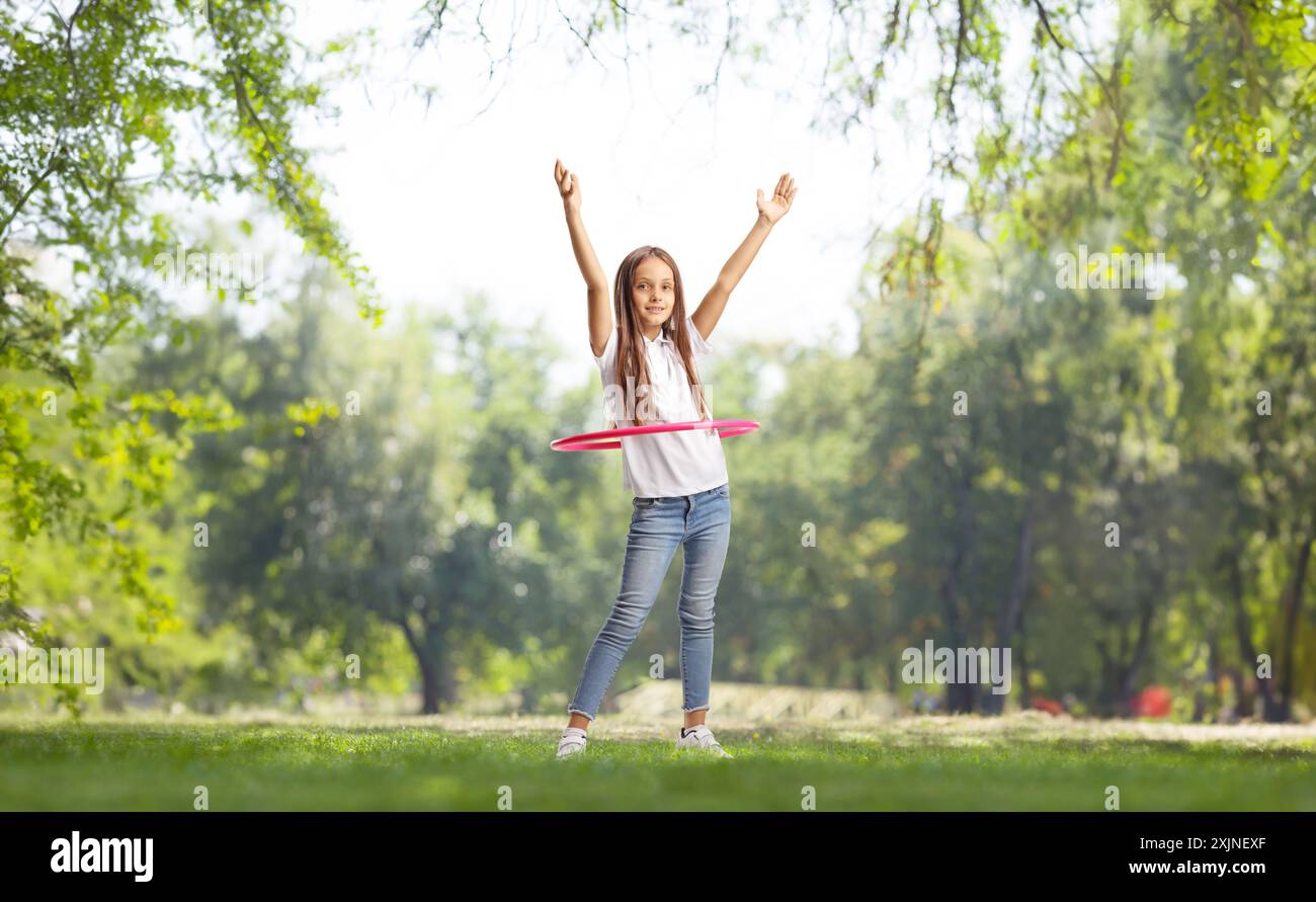 Happy girl spinning a hula hoop in a park Stock Photo - Alamy