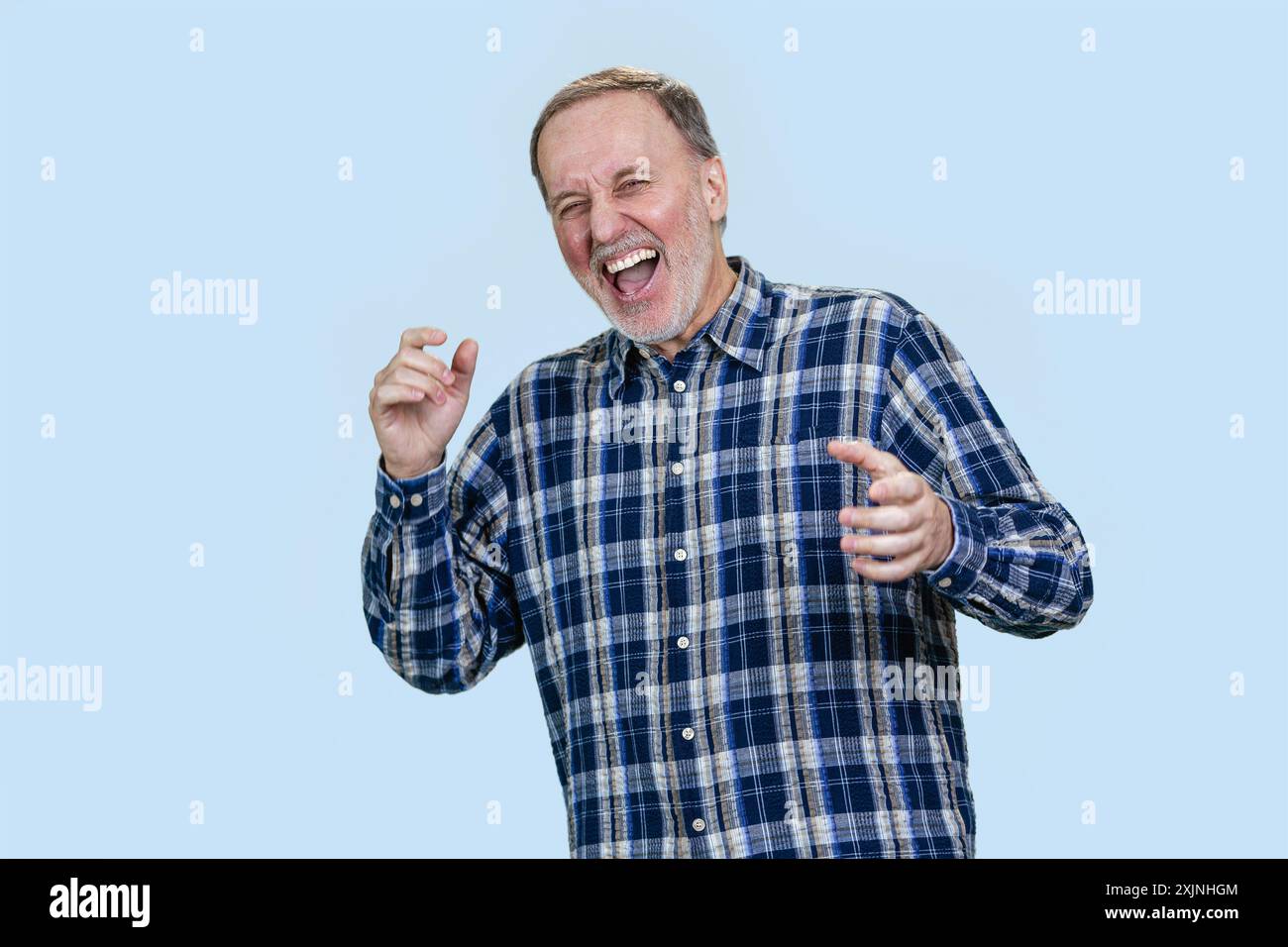 Happy mature man is laughing hard out loud. Isolated on pastel blue ...