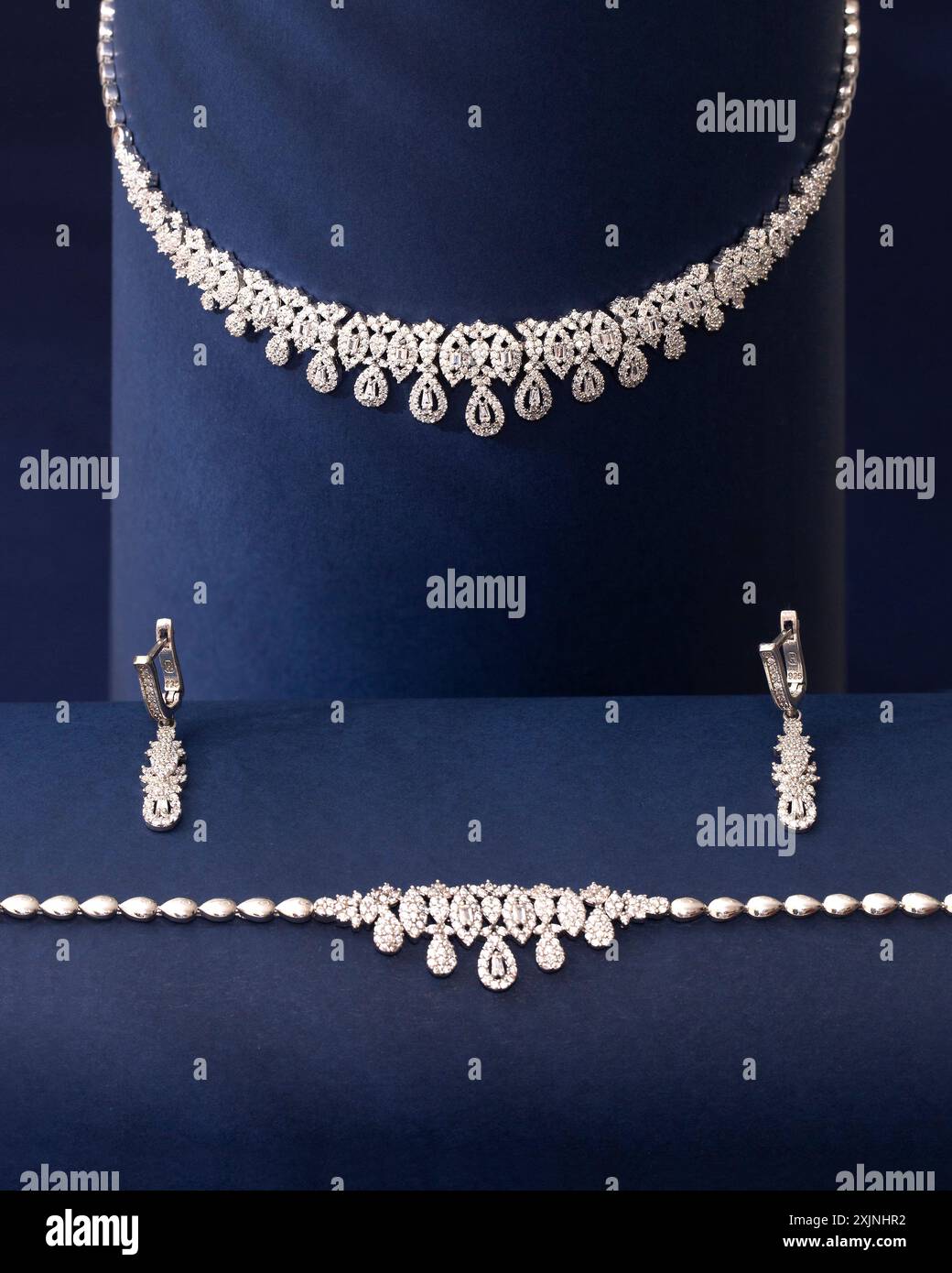 Sparkling silver jewelry set on a deep blue background Stock Photo - Alamy