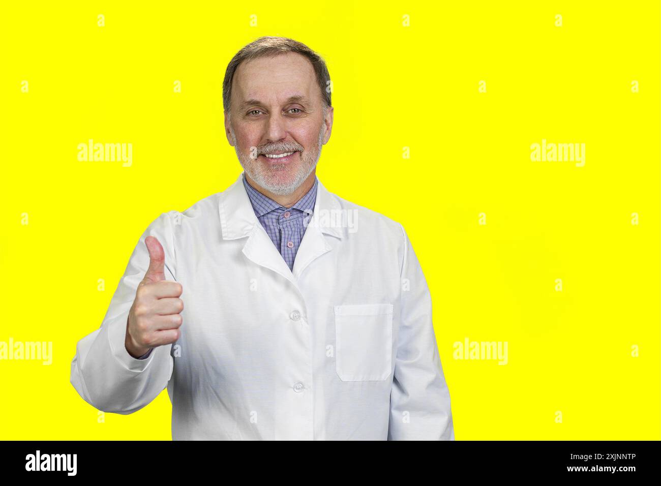 Happy male senior medic in white coat shows thumb up. Isoalted on ...