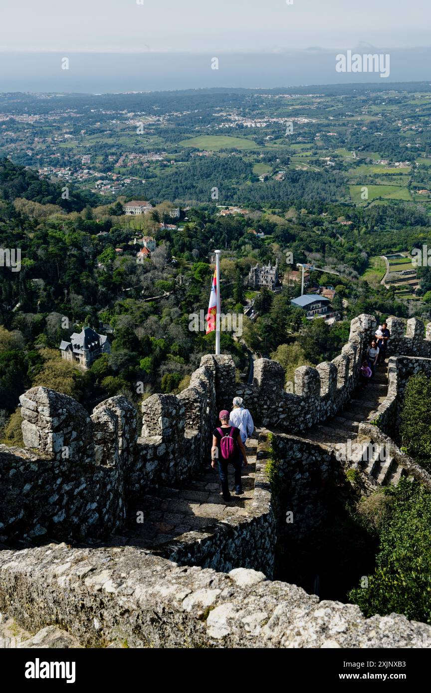 Visitors walk along the stone walls of the moorish castle in sintra ...