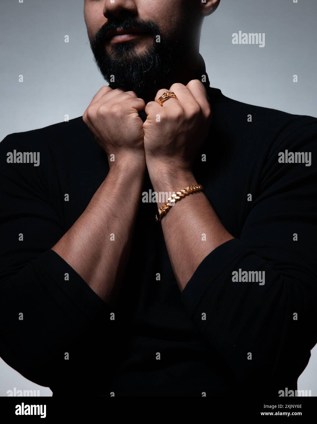 Man wearing gold jewelry, posing with clasped hands Stock Photo - Alamy