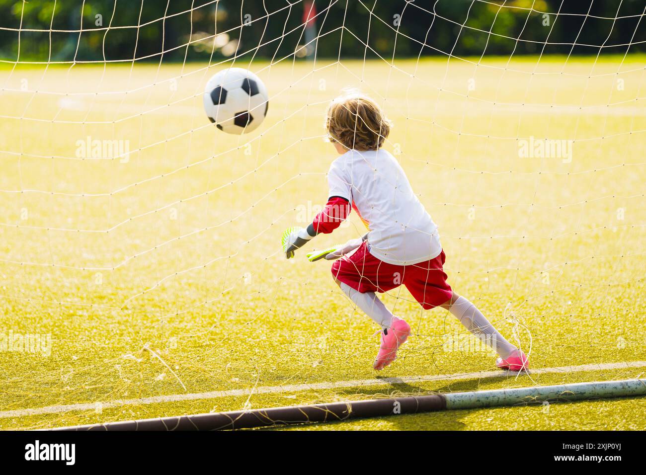 Child playing football. Kids play soccer on outdoor pitch. Little boy ...