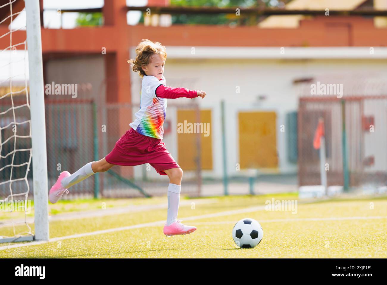 Child playing football. Kids play soccer on outdoor pitch. Little boy ...