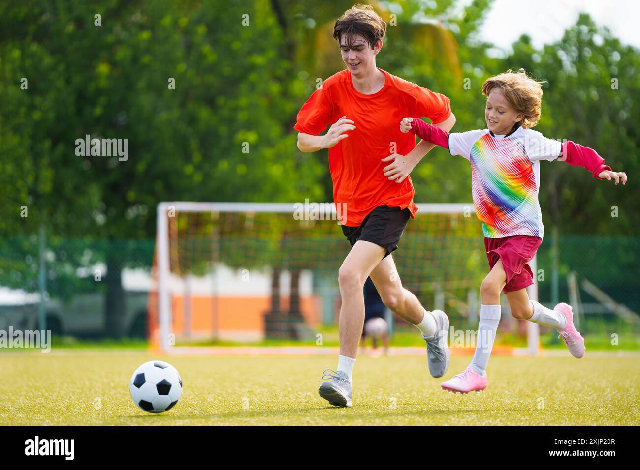Child playing football. Kids play soccer on outdoor pitch. Little boy ...
