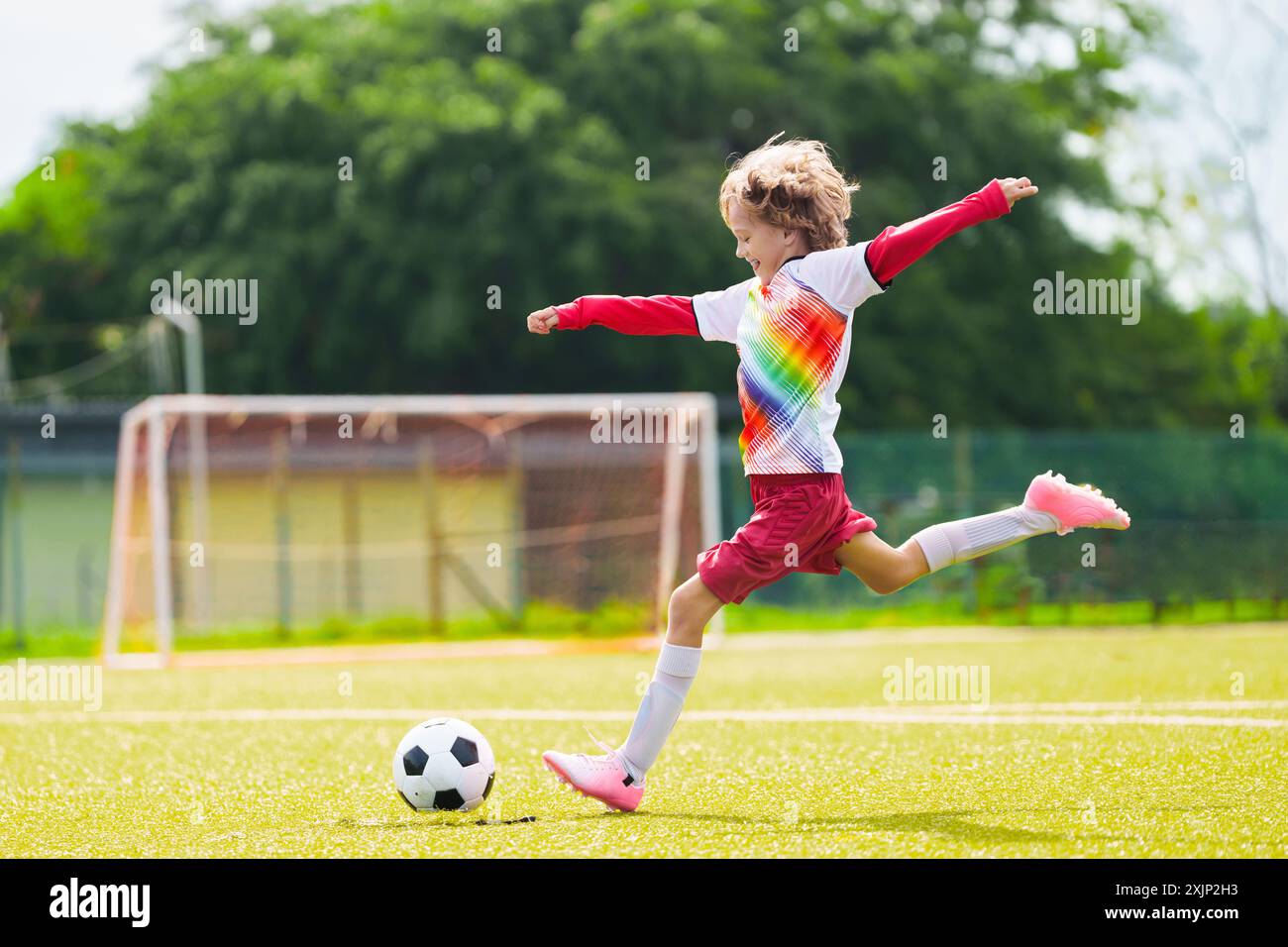 Child playing football. Kids play soccer on outdoor pitch. Little boy ...