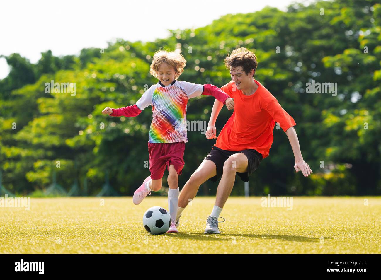 Child playing football. Kids play soccer on outdoor pitch. Little boy ...