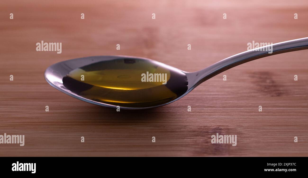 Tablespoon of olive oil. Close up picture on a wooden background Stock ...