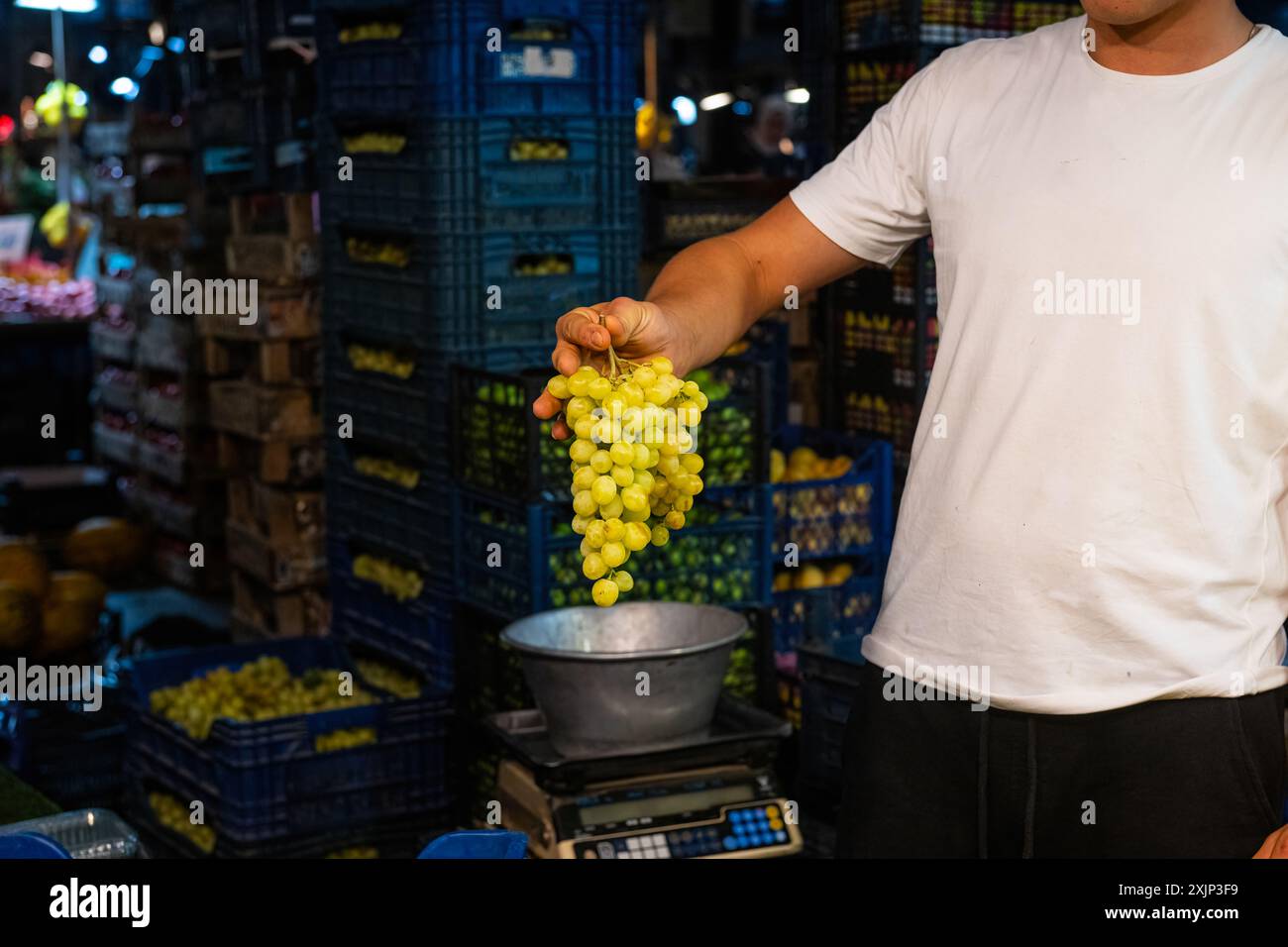 Grapes on the market stall. Man holding bunch of grapes Stock Photo - Alamy