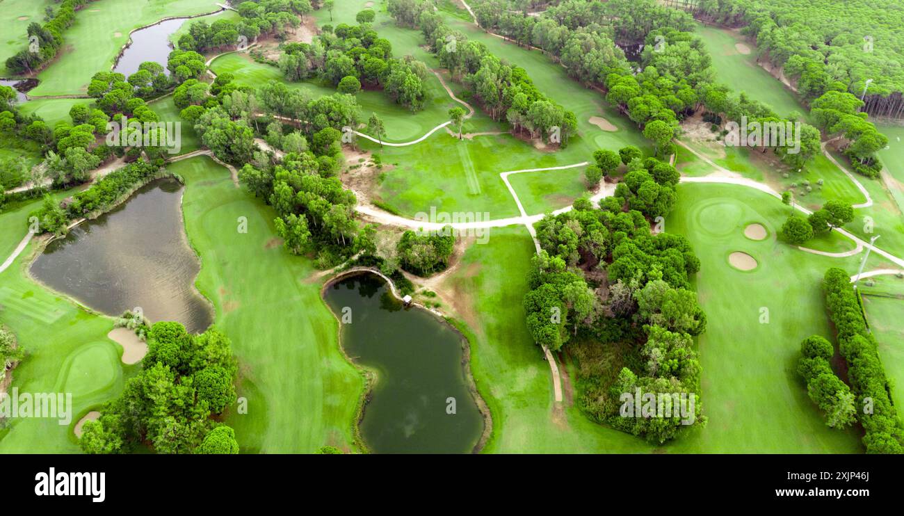 Golf course at sunset with beautiful trees, pond and sand traps. Scenic ...