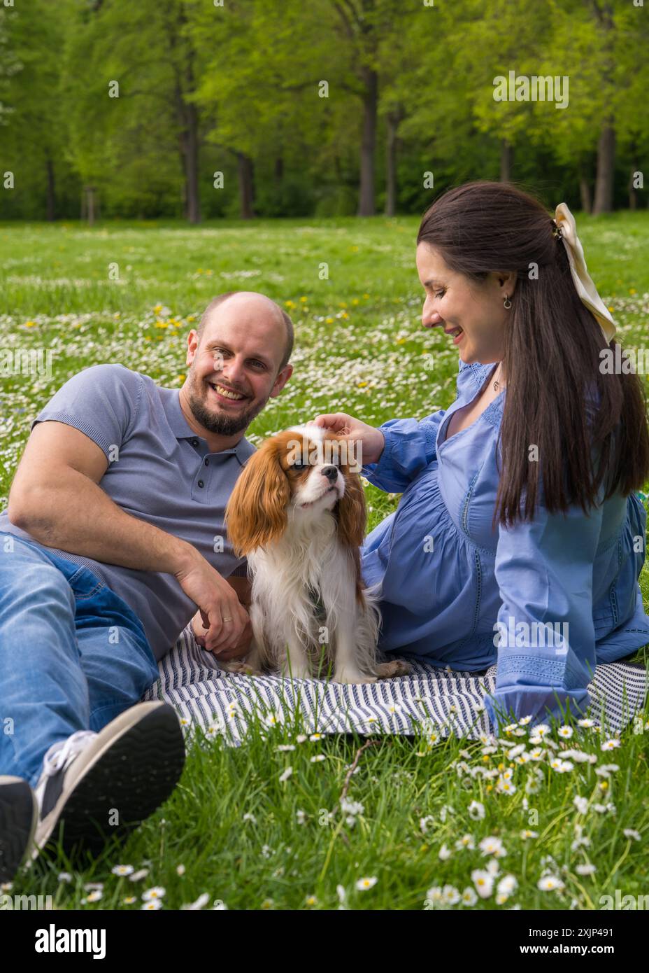 Happy pregnant couple spends time together on a picnic outdoors with a ...
