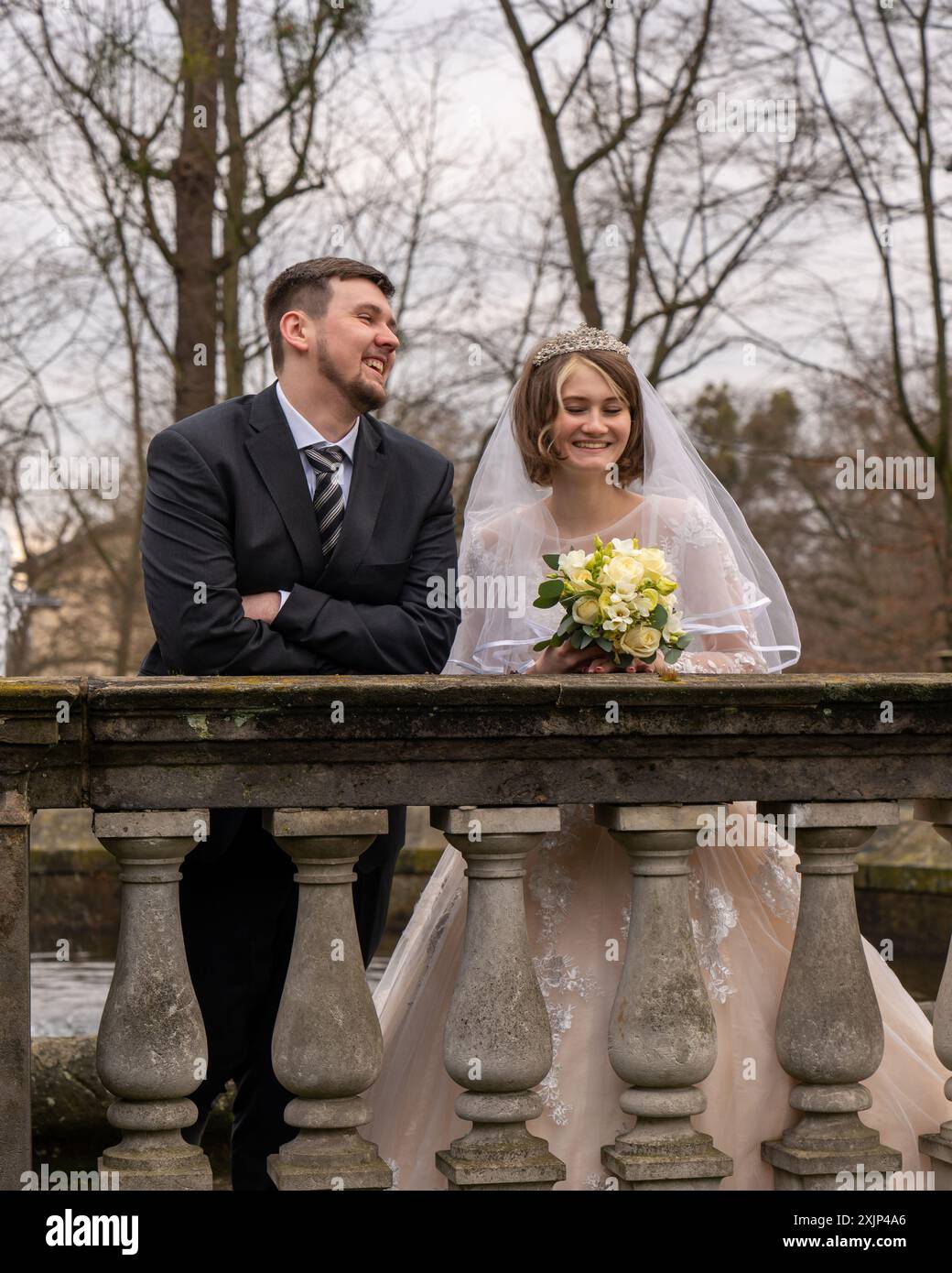 The bride and groom are standing on the balcony of an ancient castle ...