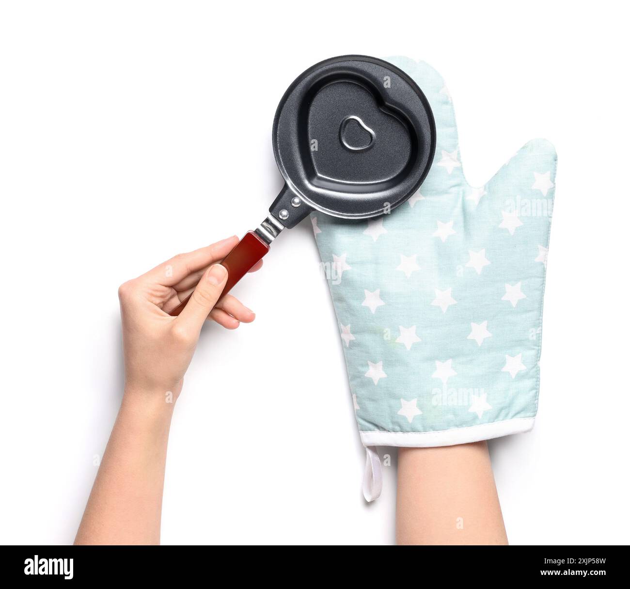 Female hands in oven mitten holding heart-shaped frying pan on white ...