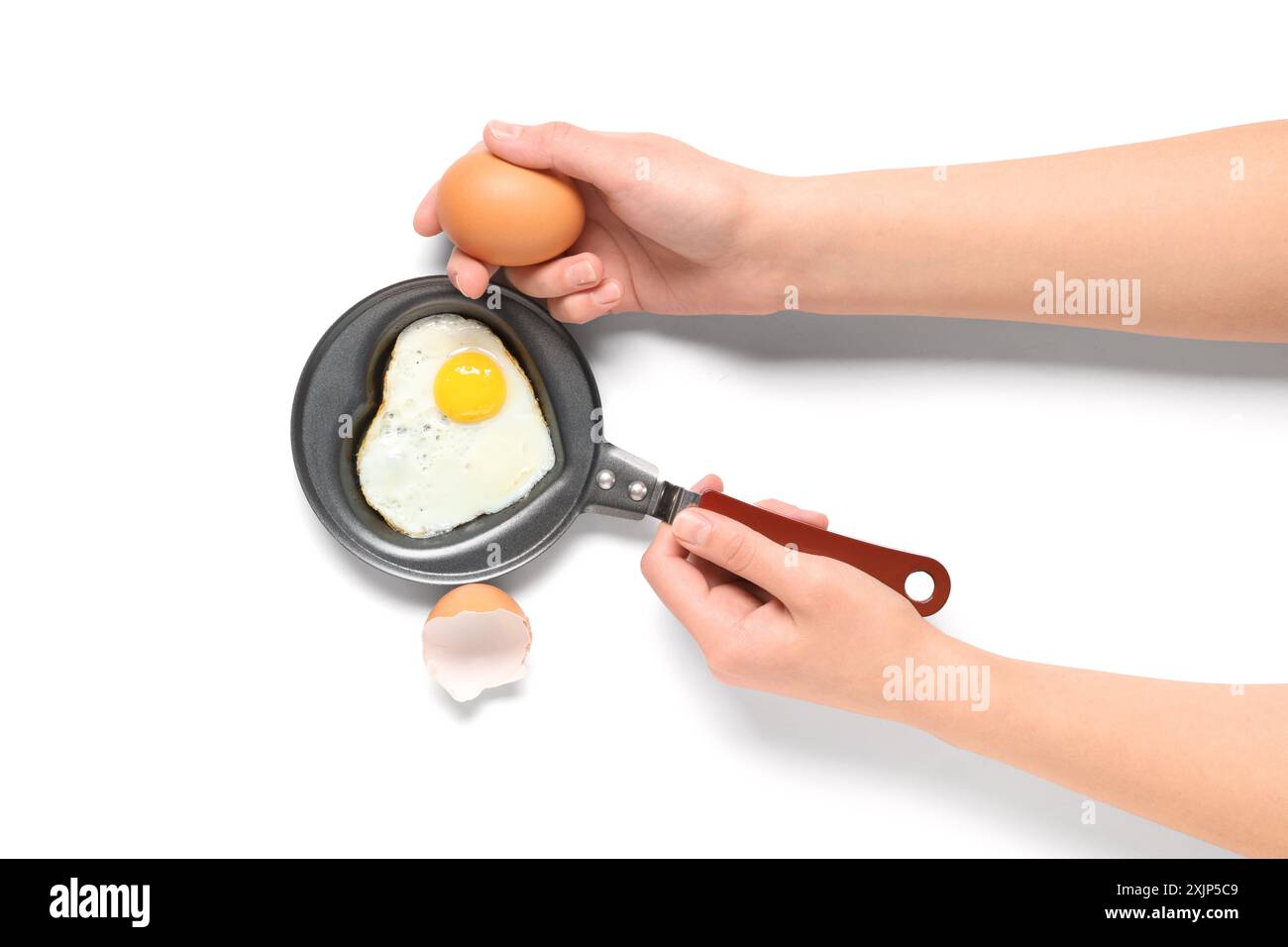 Frying pan with heart-shaped fried egg and female hands on white background Stock Photo - Alamy