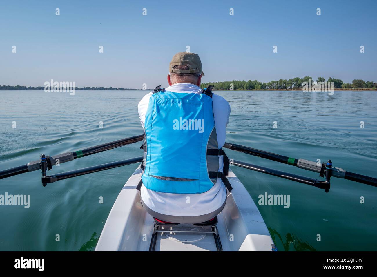 senior male in a rowing shell on calm lake, POV from a boat bow Stock ...