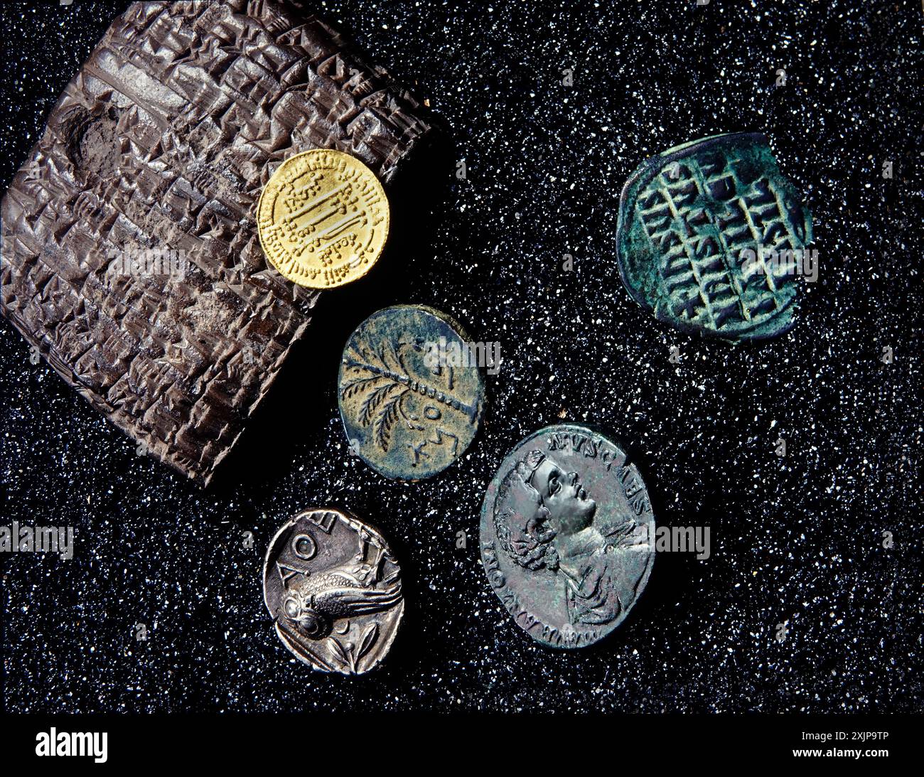 An ancient clay tablet with cuneiform script is displayed next to five ...