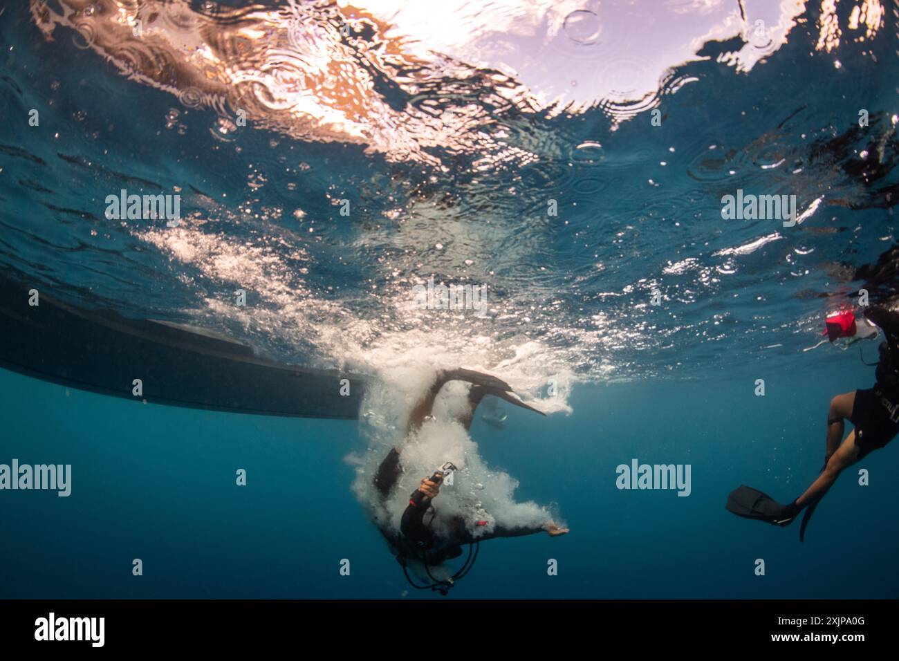 A Mexican diver conducts a back roll off a ridged hull inflatable boat ...