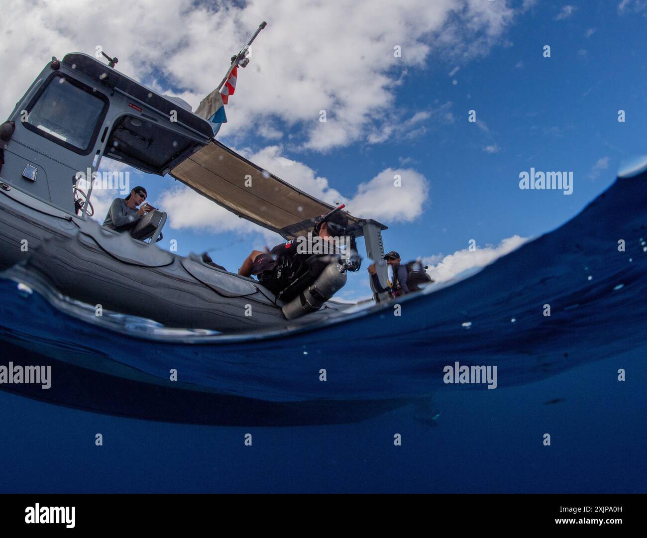 A Mexican diver conducts a back roll off a ridged hull inflatable boat ...