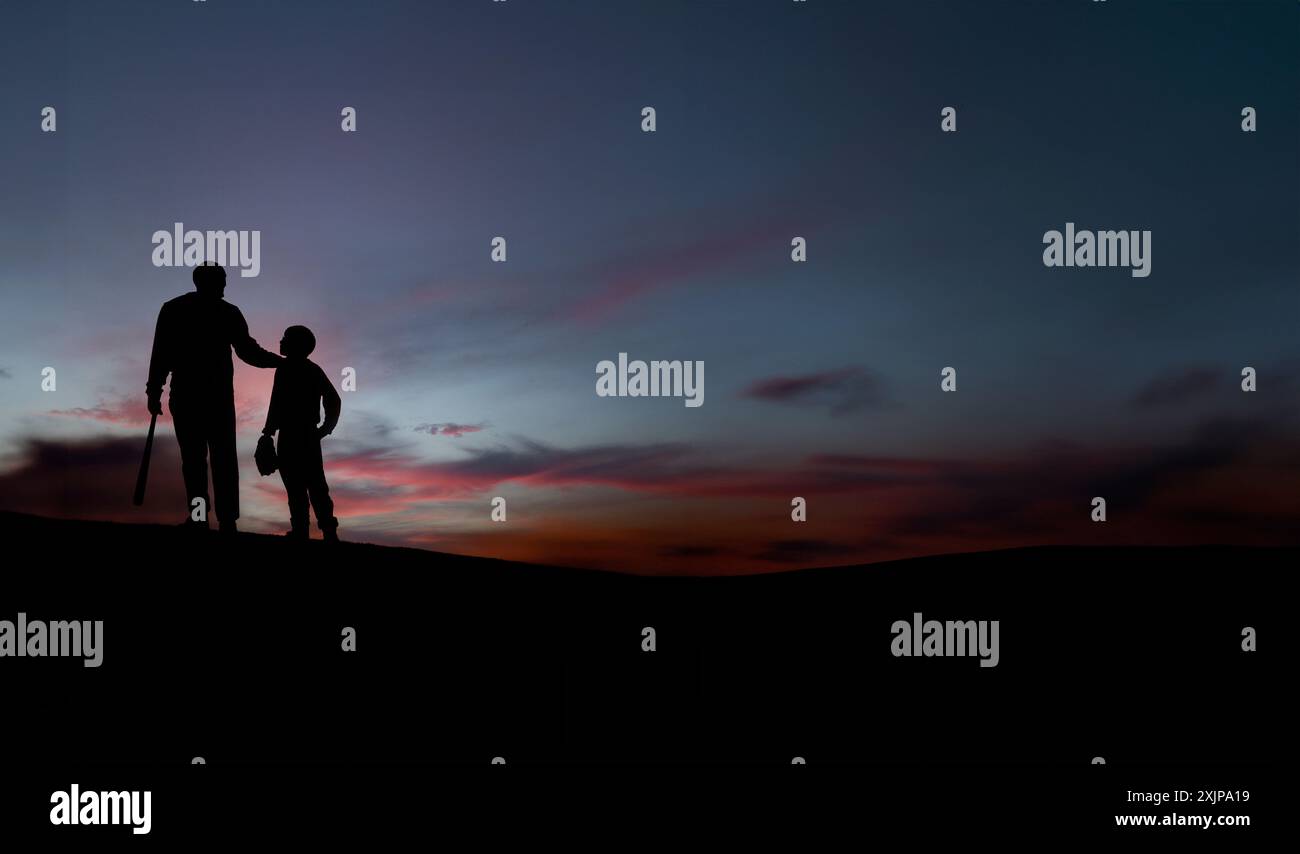 A father and his son stand silhouetted against a beautiful sunset sky ...