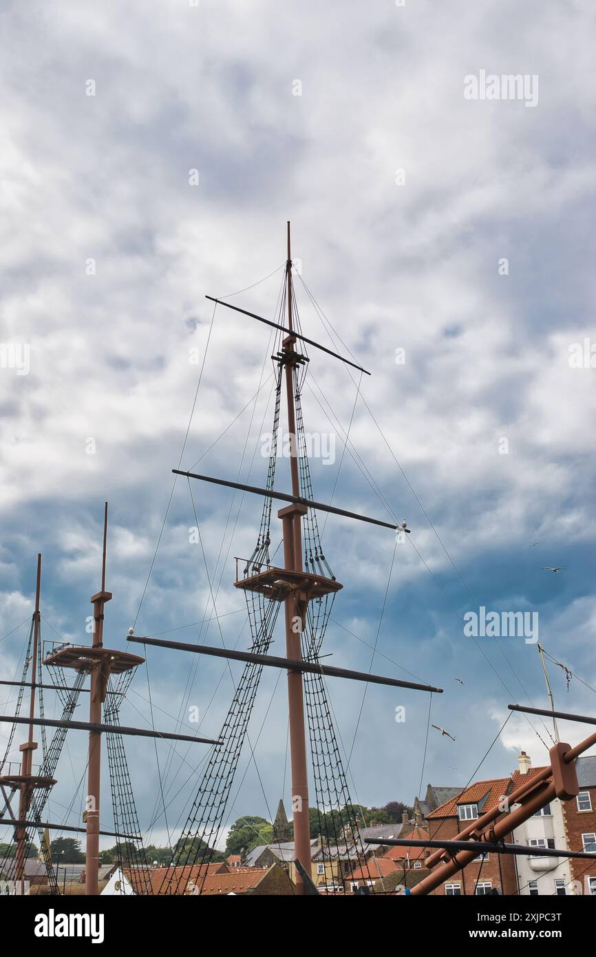 Tall ship masts with rigging against a cloudy sky in a harbor Stock ...