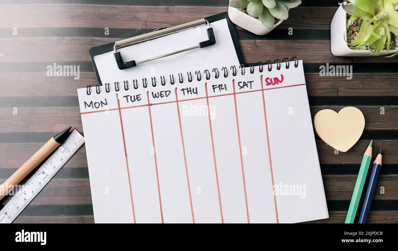 Concept of Weekly Calendar write on book isolated on Wooden Table Stock ...