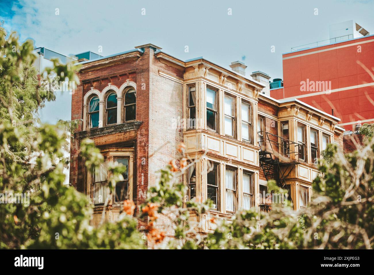 A historic brick building with large windows is partially obscured by ...