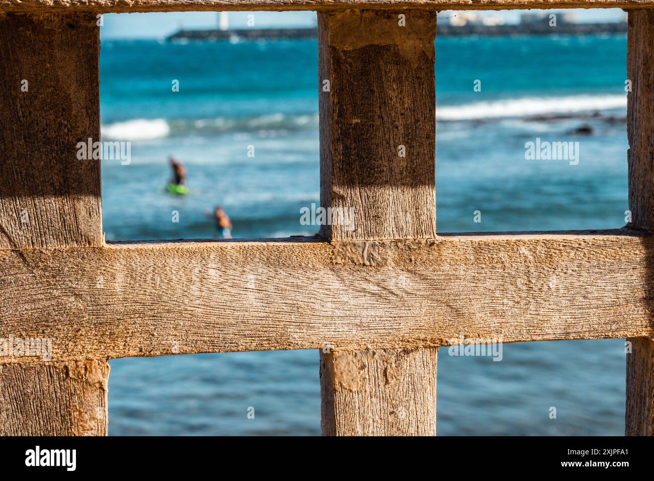 view of the sea from small holes in worn wood. wallpaper Stock Photo ...